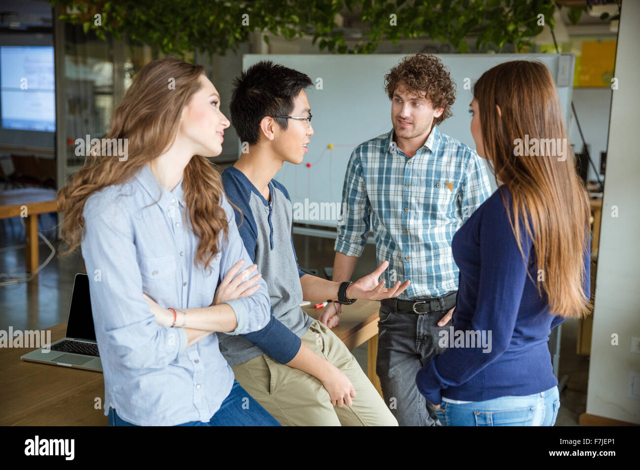 Group of young attractive people talking and discussing new project in ...