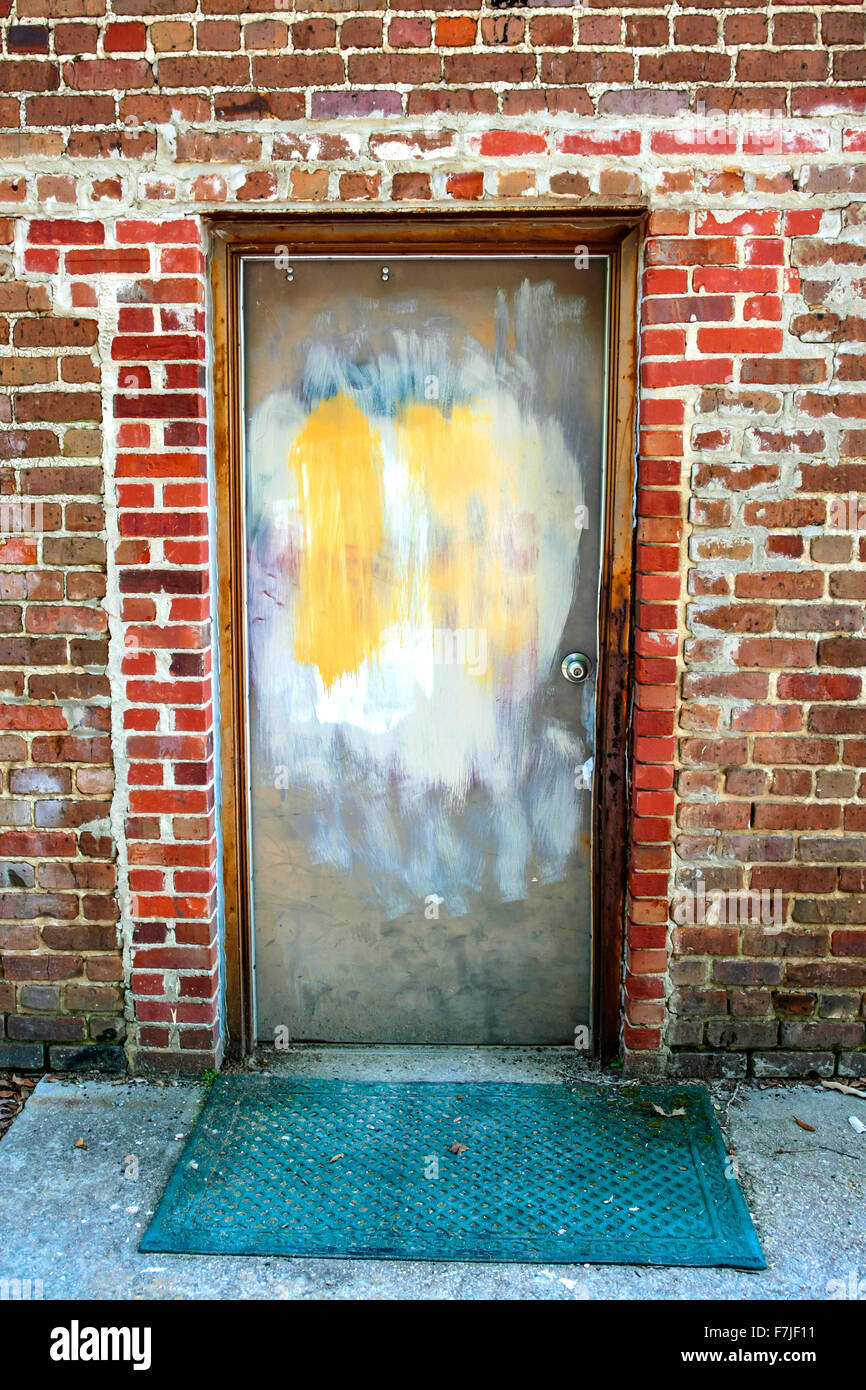 Beaten up door with a redbrick surround in an alley in downtown ...