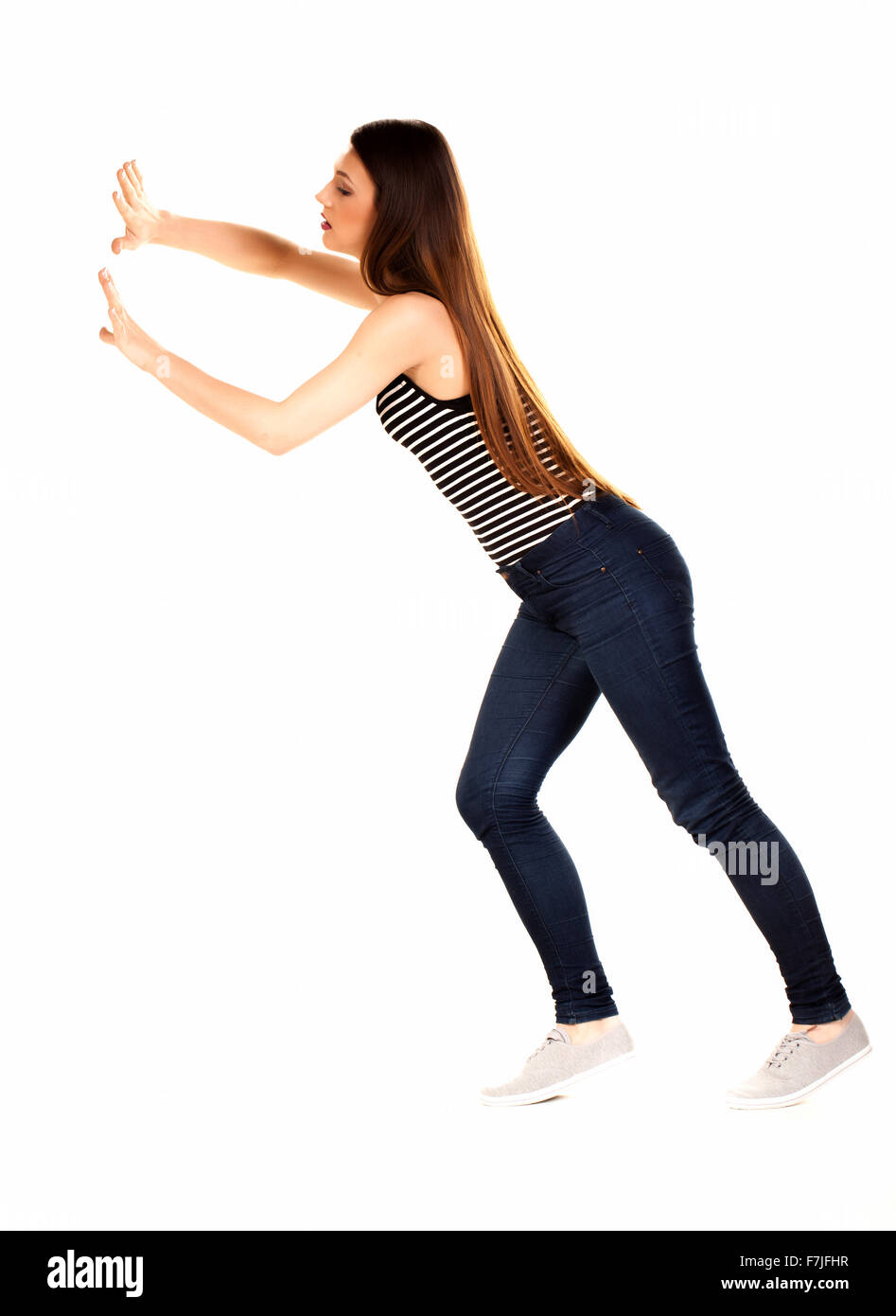 Woman pushing something imaginary isolated over a white background ...