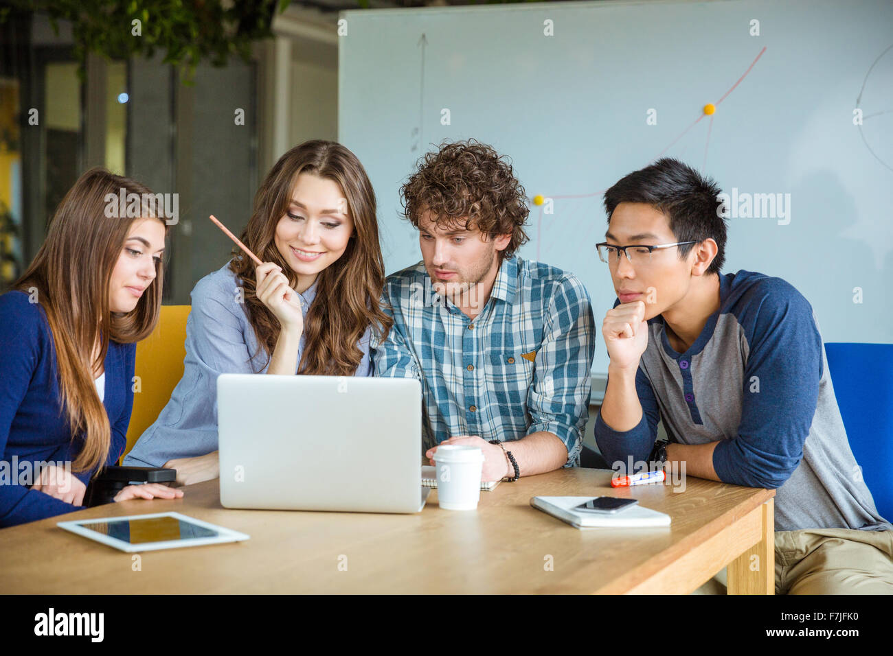 Group of concentrated smart students sitting in classroom and using ...