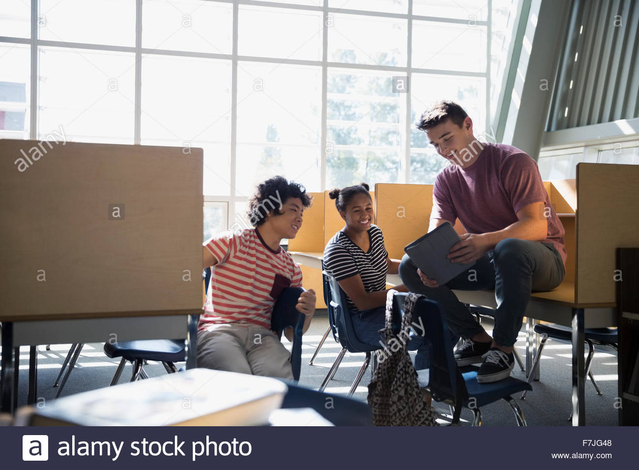 High school students using digital tablet in library Stock Photo - Alamy