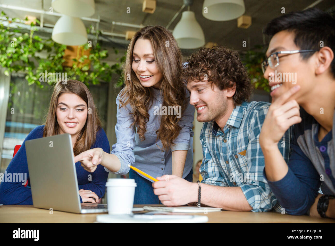 Group of enthusiastic cheerful colleagues discussing ideas and planning ...