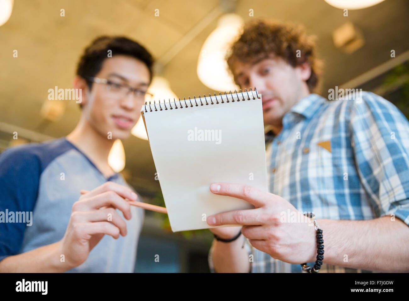 Student showing his notes in notepad to his friend Stock Photo - Alamy