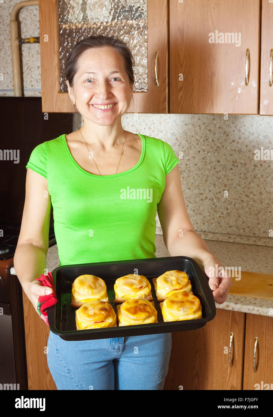 Woman with cooked baked stuffed vegetable marrow. See in series stages ...