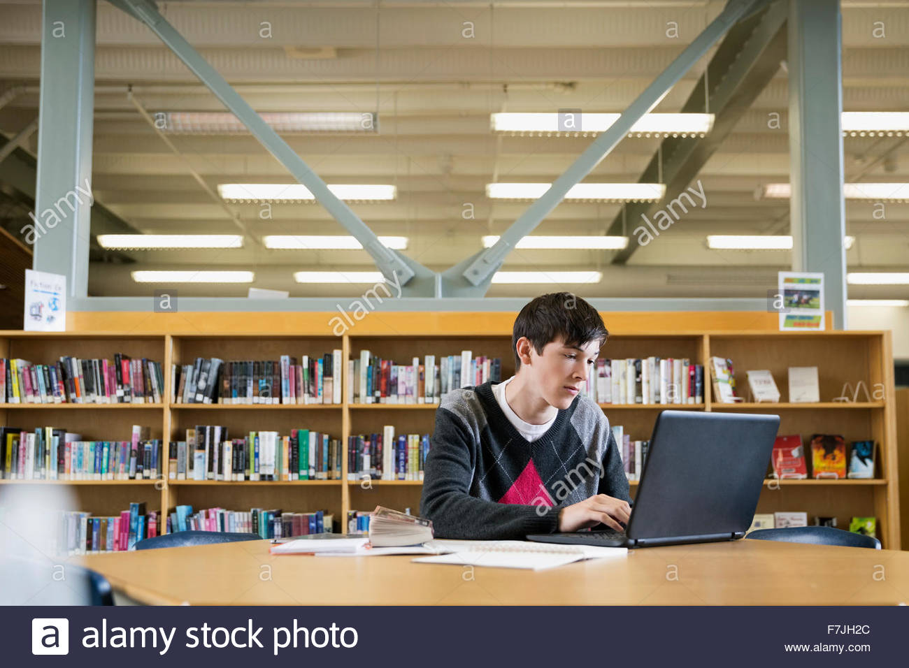 Focused high school student using laptop in library Stock Photo - Alamy