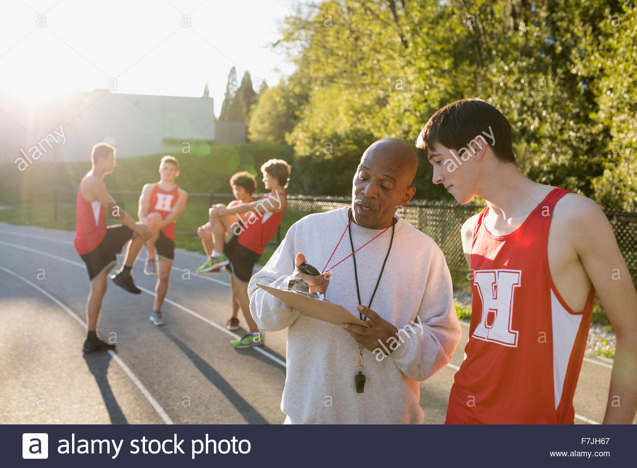 Coach timing high school track and field athlete Stock Photo - Alamy