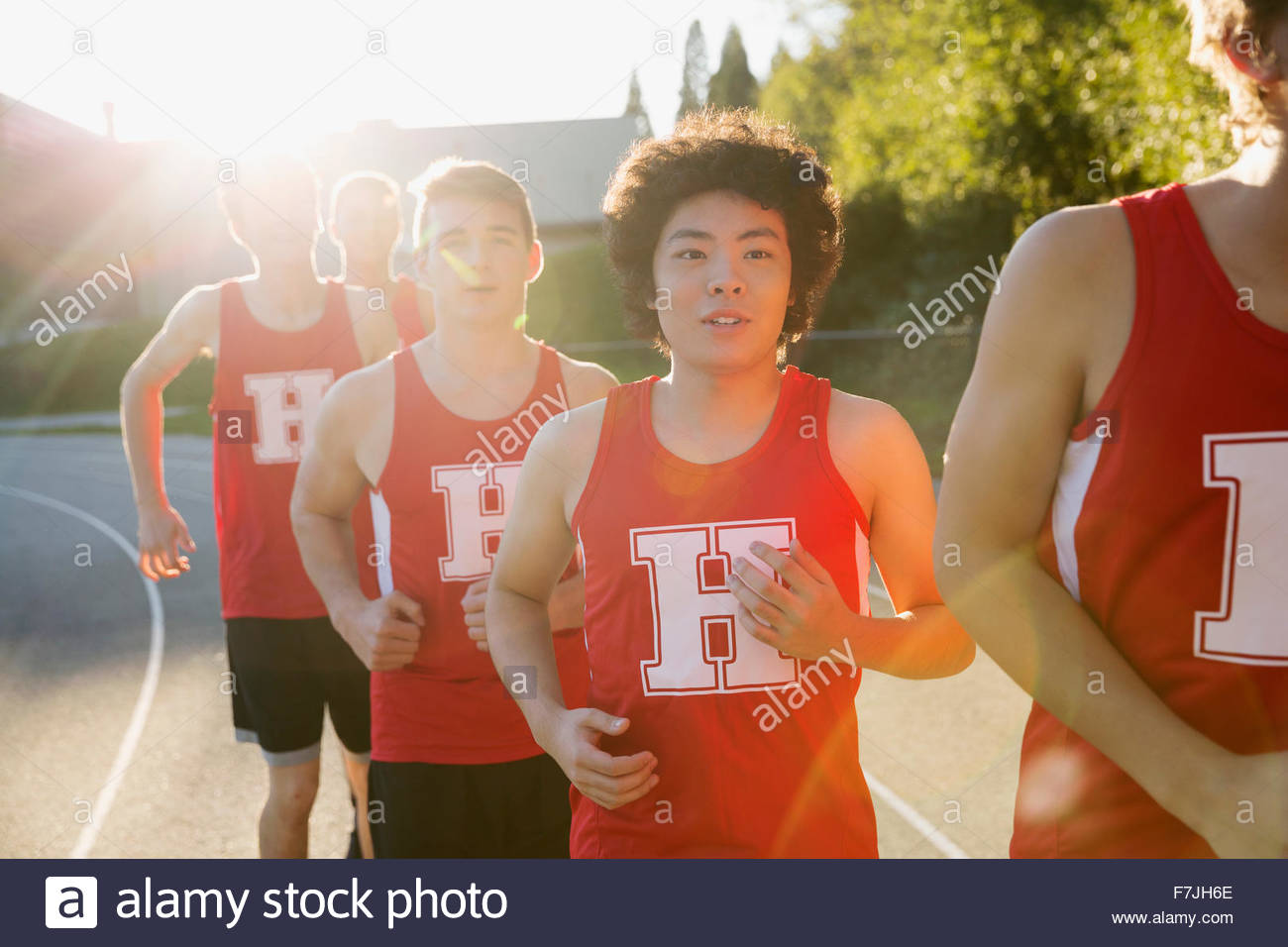 Focused high school track and field athletes jogging Stock Photo - Alamy