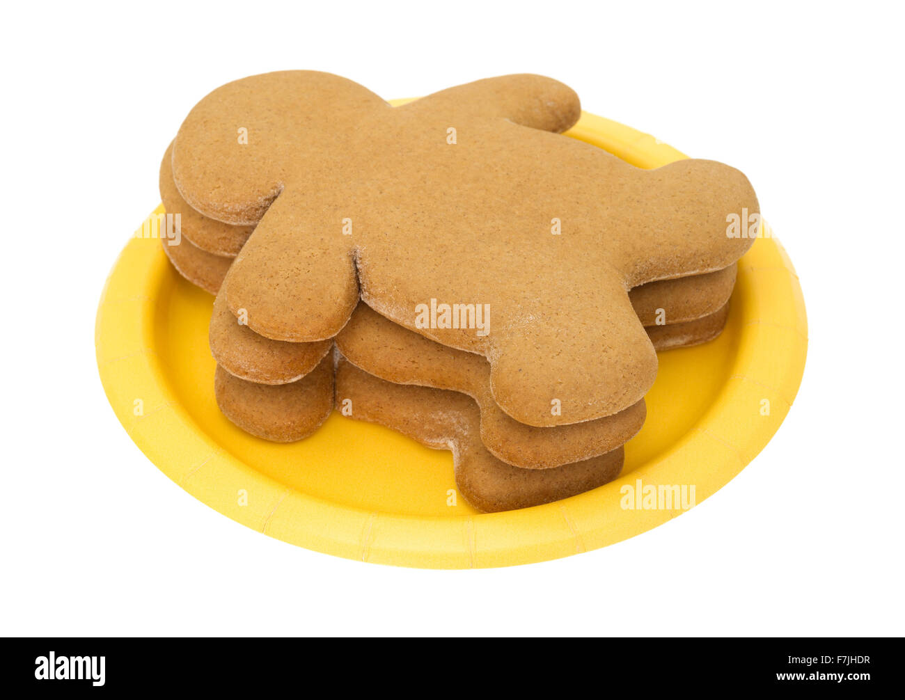Three freshly baked gingerbread men on a small paper yellow plate ...