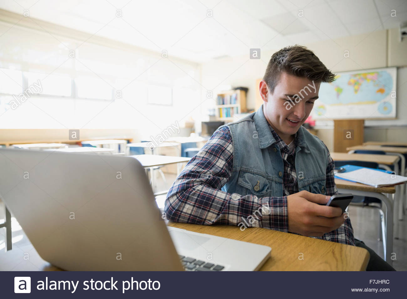 High school student texting at desk in classroom Stock Photo - Alamy