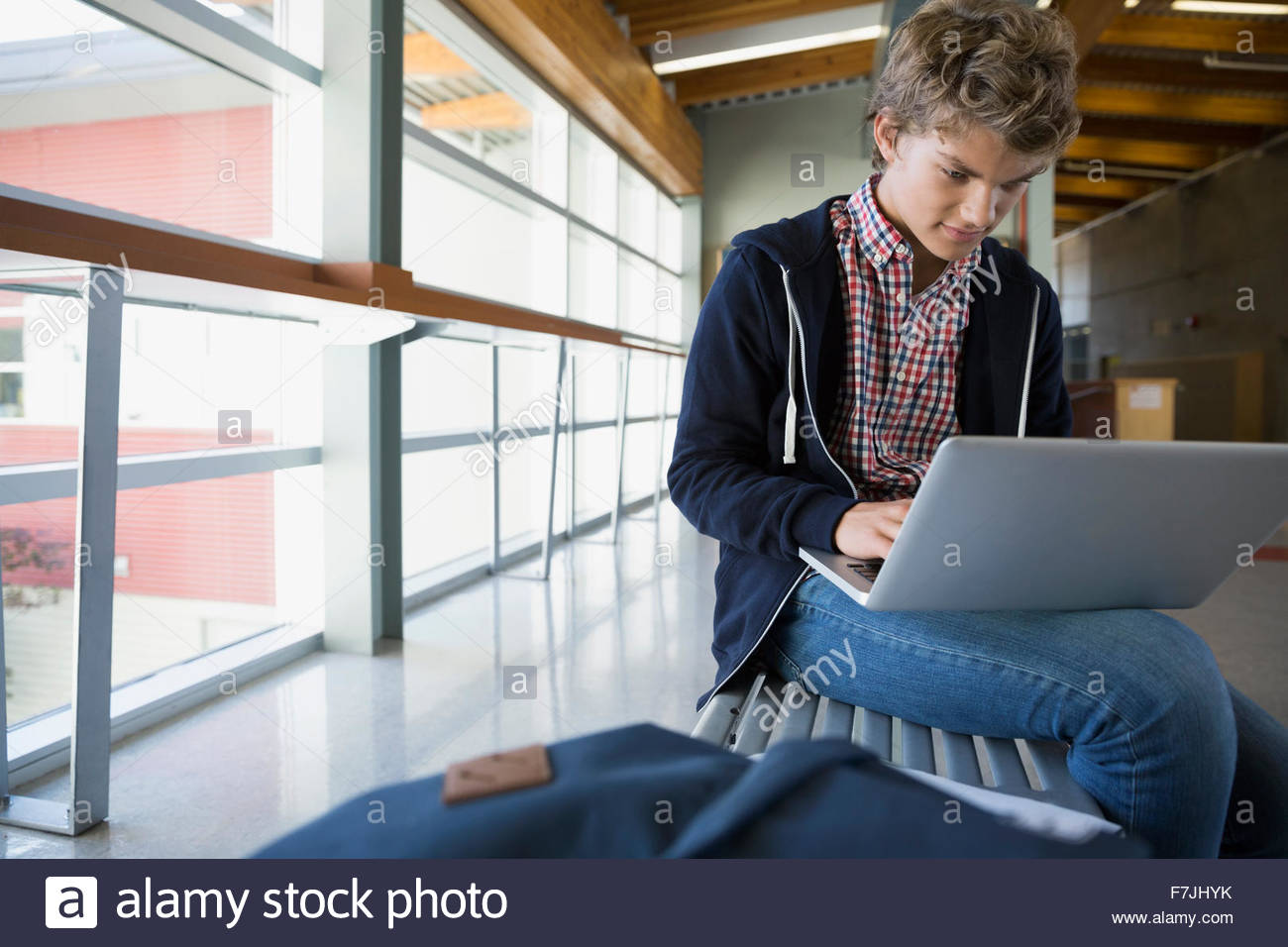 High school student using laptop on bench Stock Photo - Alamy