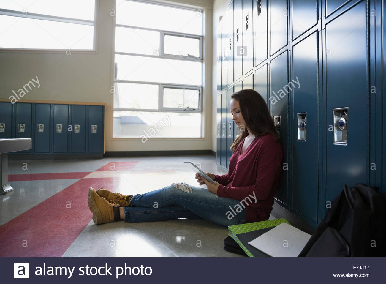 High school student using digital tablet at lockers Stock Photo - Alamy