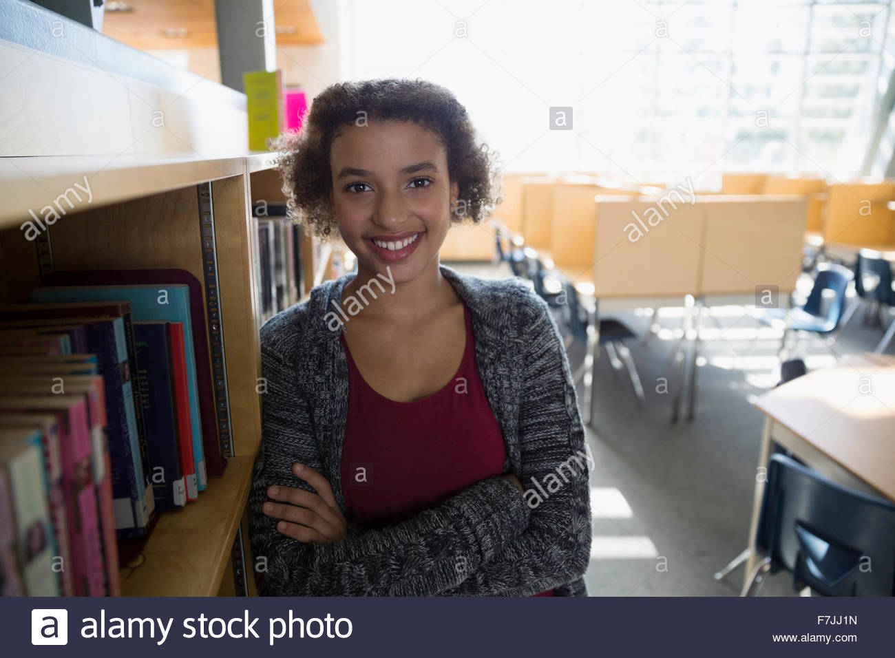 Portrait confident high school student leaning library shelves Stock ...