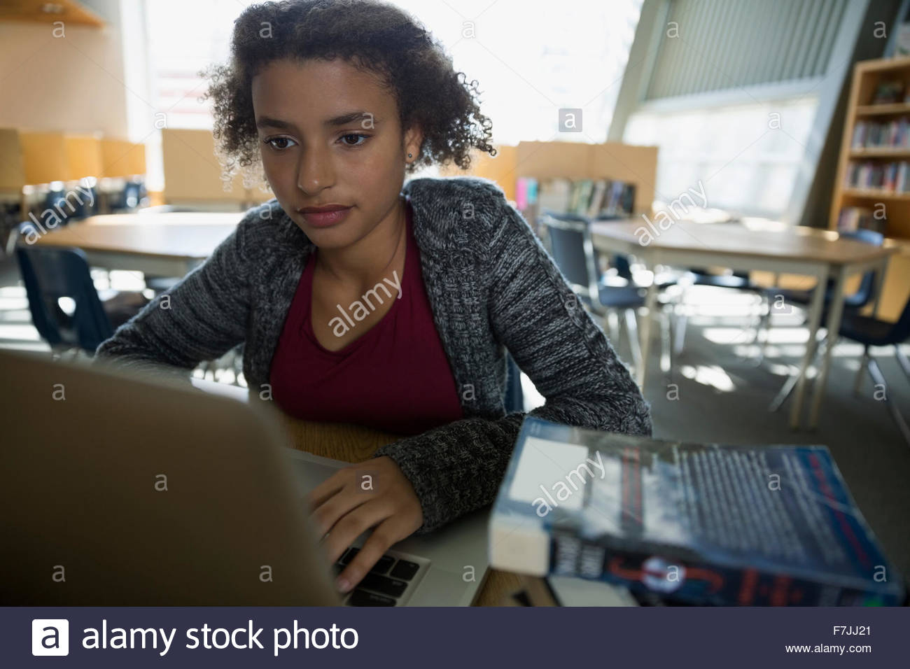 Focused high school student using laptop in library Stock Photo - Alamy