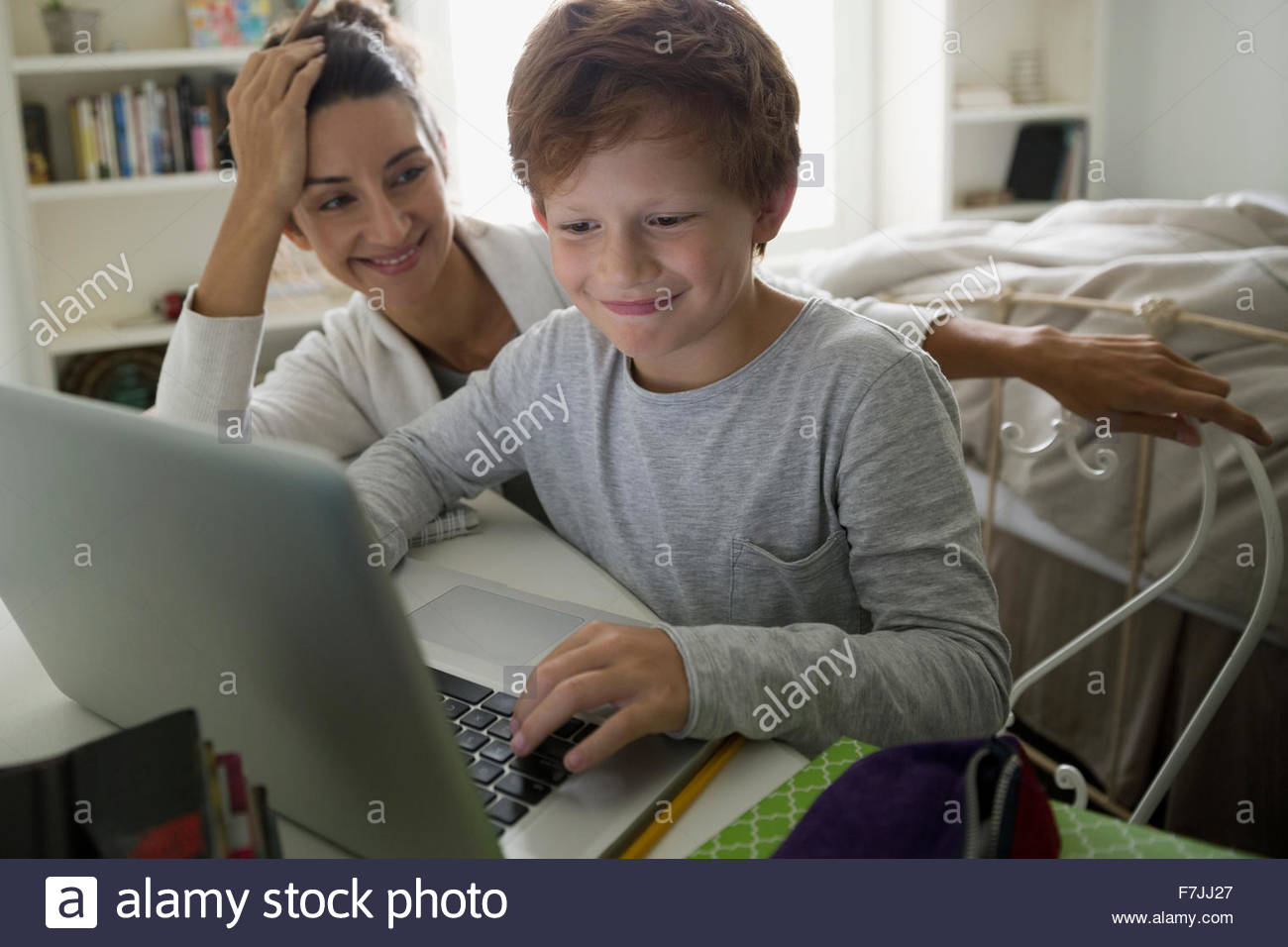 Mother helping son with homework at laptop bedroom Stock Photo - Alamy