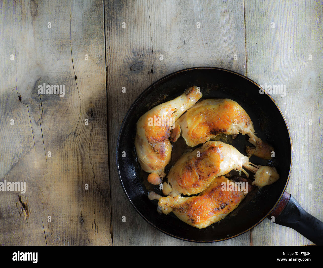 Roasted chicken thighs in a pan on old weathering wooden table. 28th ...