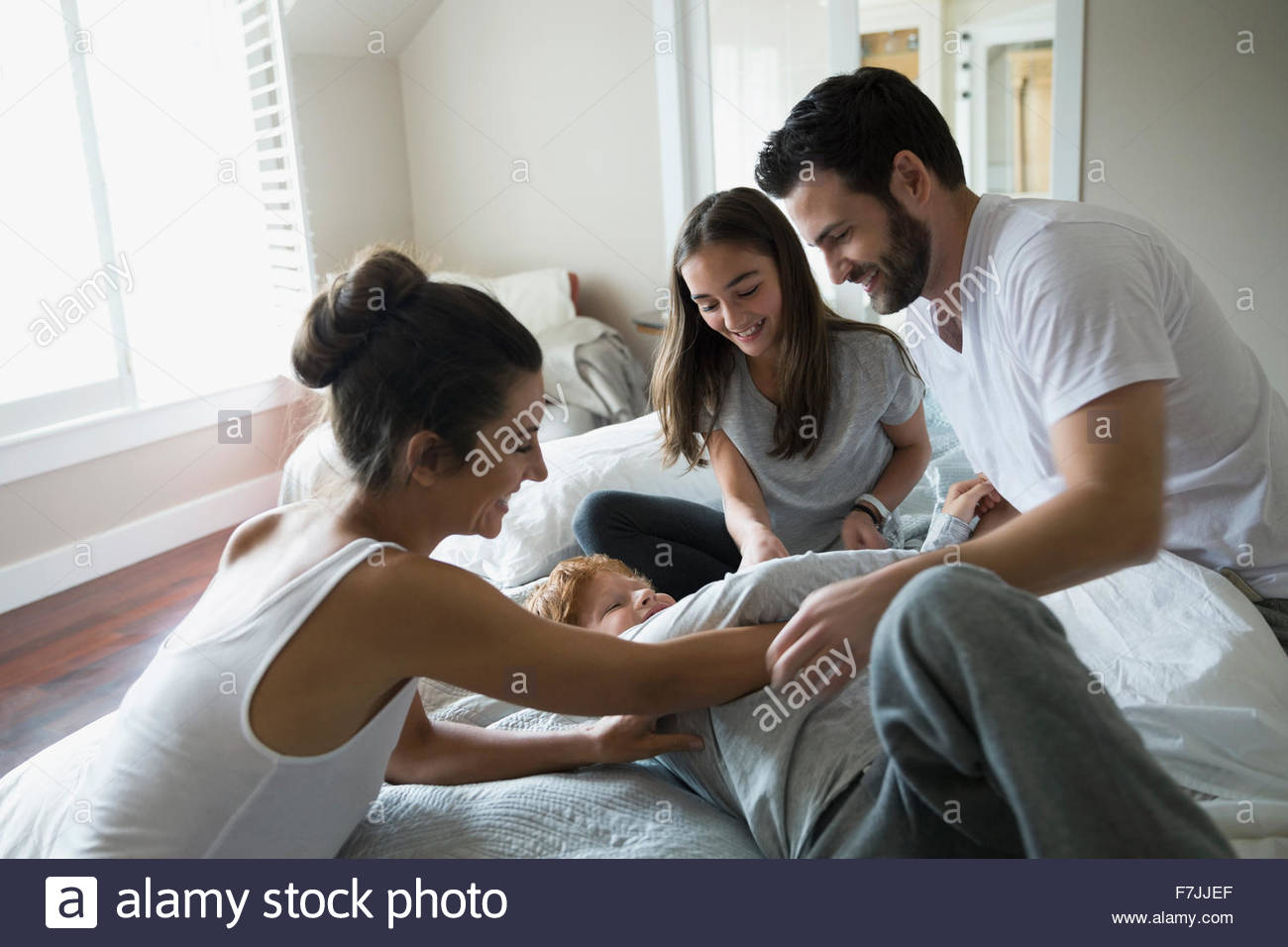Children tickling boy hi-res stock photography and images - Alamy