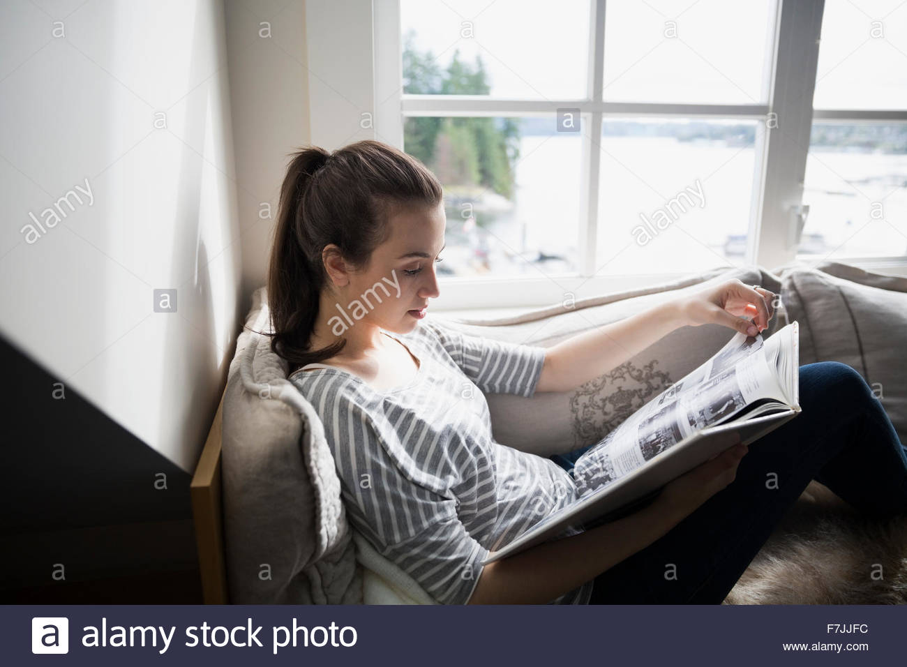 Woman reading at window hi-res stock photography and images - Alamy
