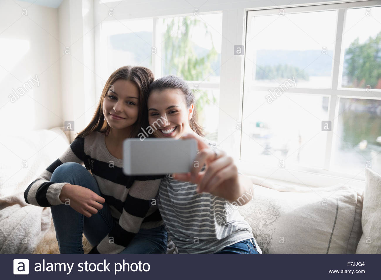 Sisters taking selfie at window seat Stock Photo - Alamy