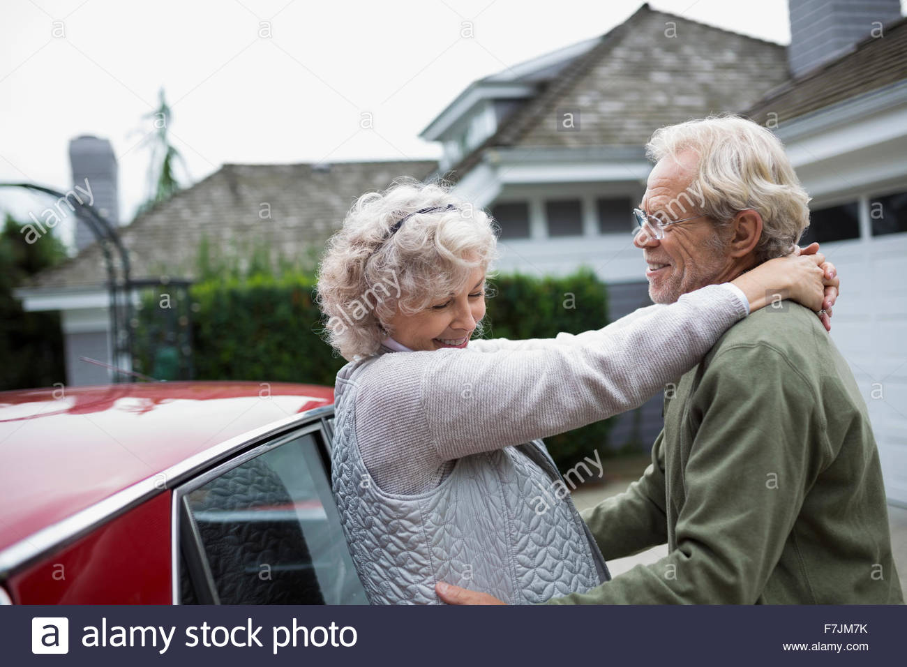 Senior couple hugging outside car in driveway Stock Photo - Alamy