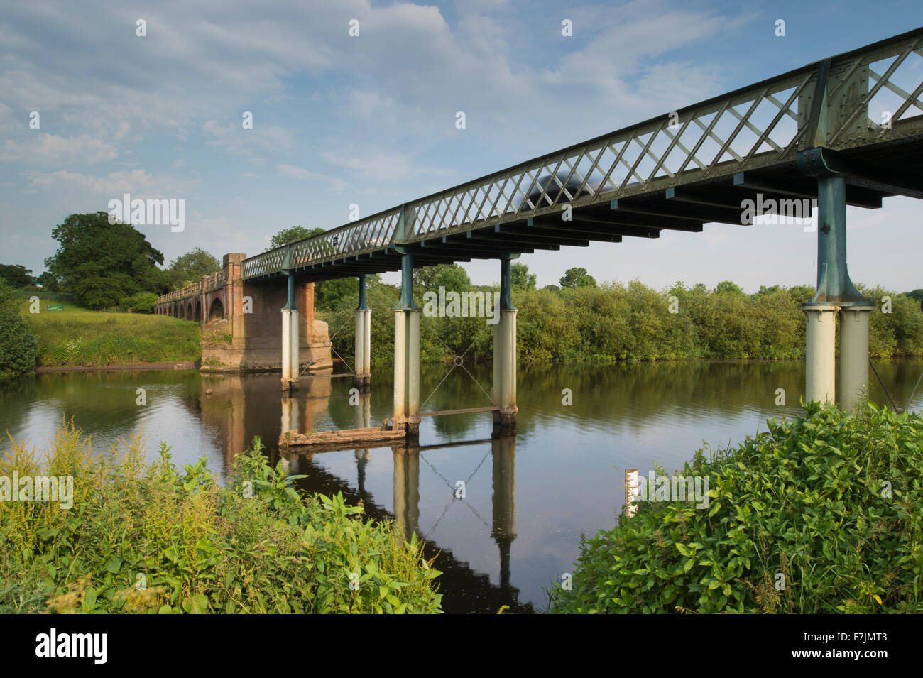 Summer sun and blue sky, cars travel across narrow Aldwark Toll Bridge ...