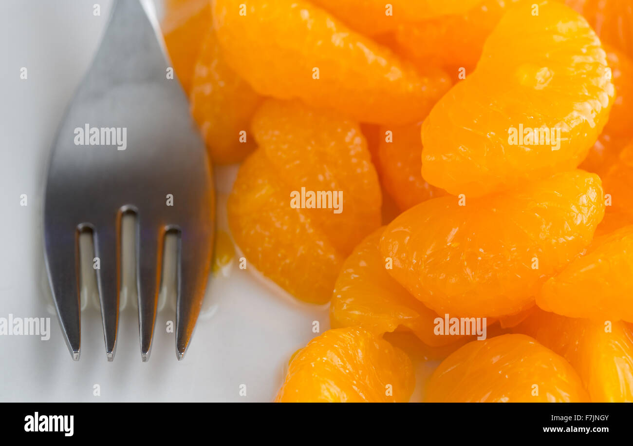 Close view of a serving of canned mandarin oranges on a white plate ...