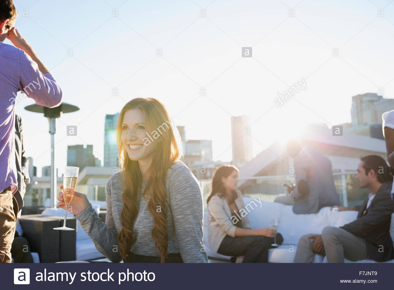 Business people drinking champagne on sunny urban rooftop Stock Photo ...
