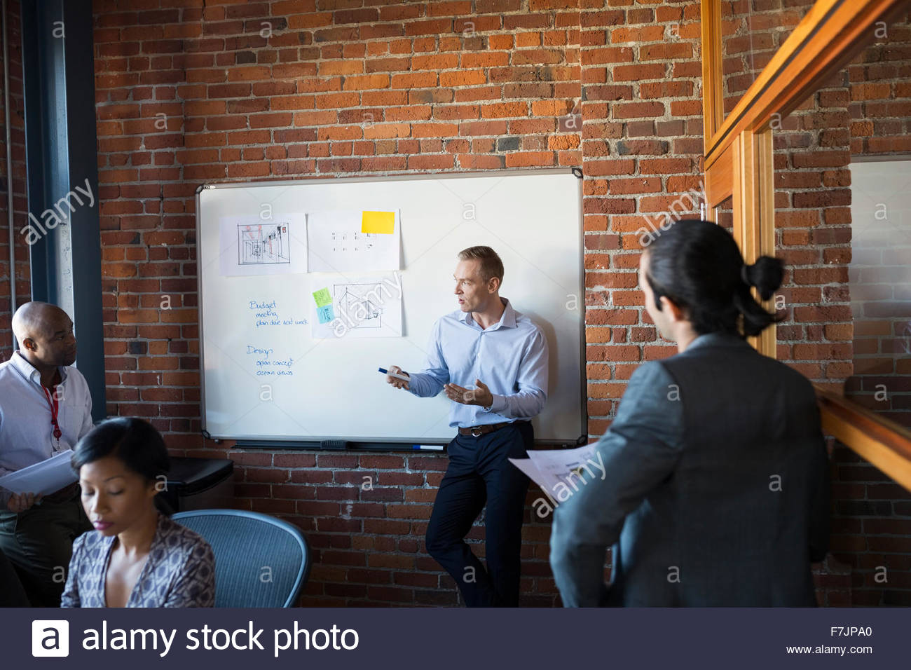 Business people meeting at whiteboard in conference room Stock Photo ...