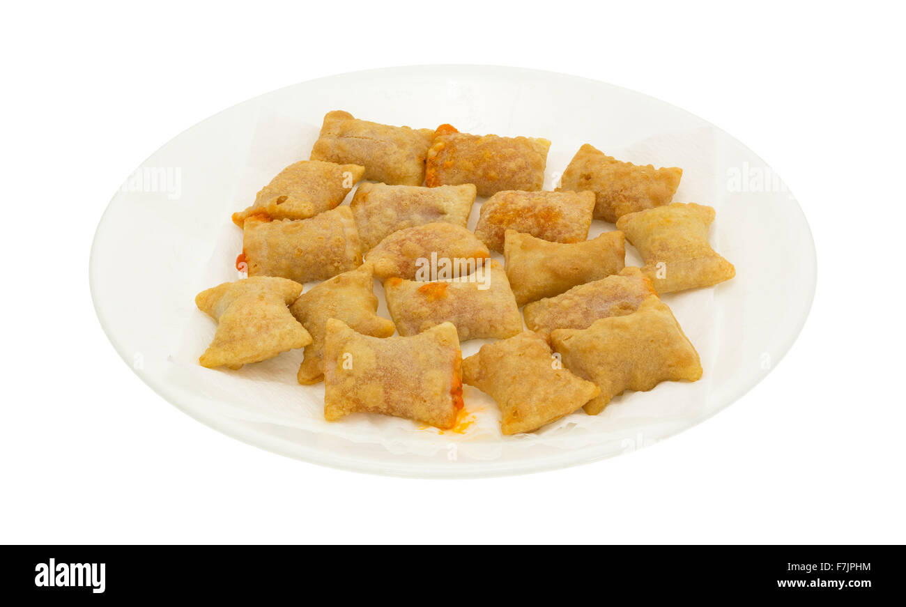 A serving of bite size pizza rolls on a white paper napkin atop a plate ...