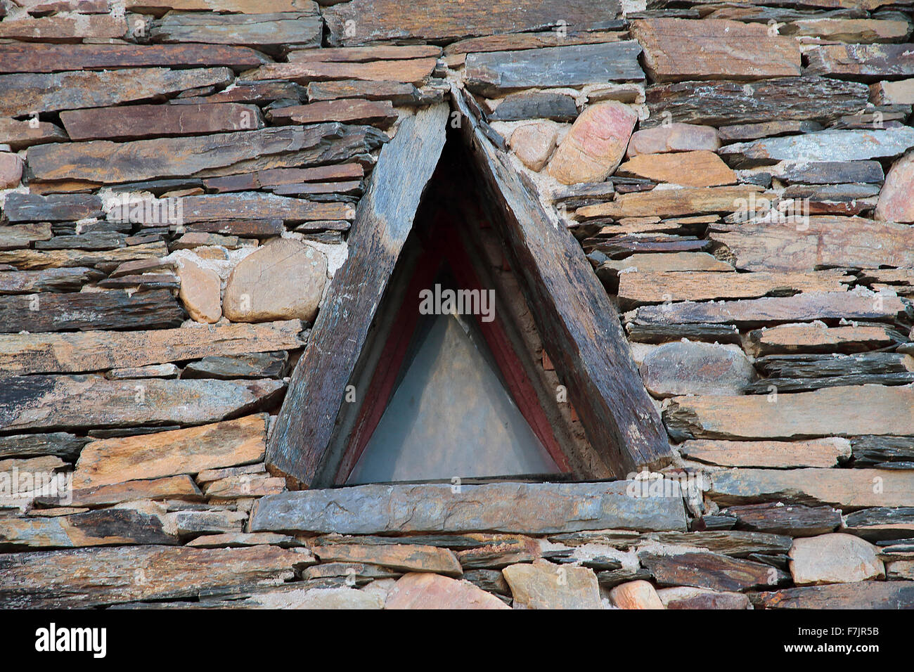 triangular window in a wall built of slate, typical of the villages of ...