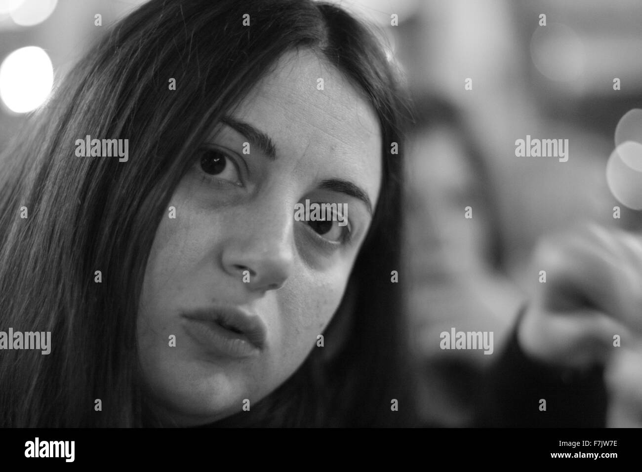Young woman with a plain expressionless look staring at the camera with ...