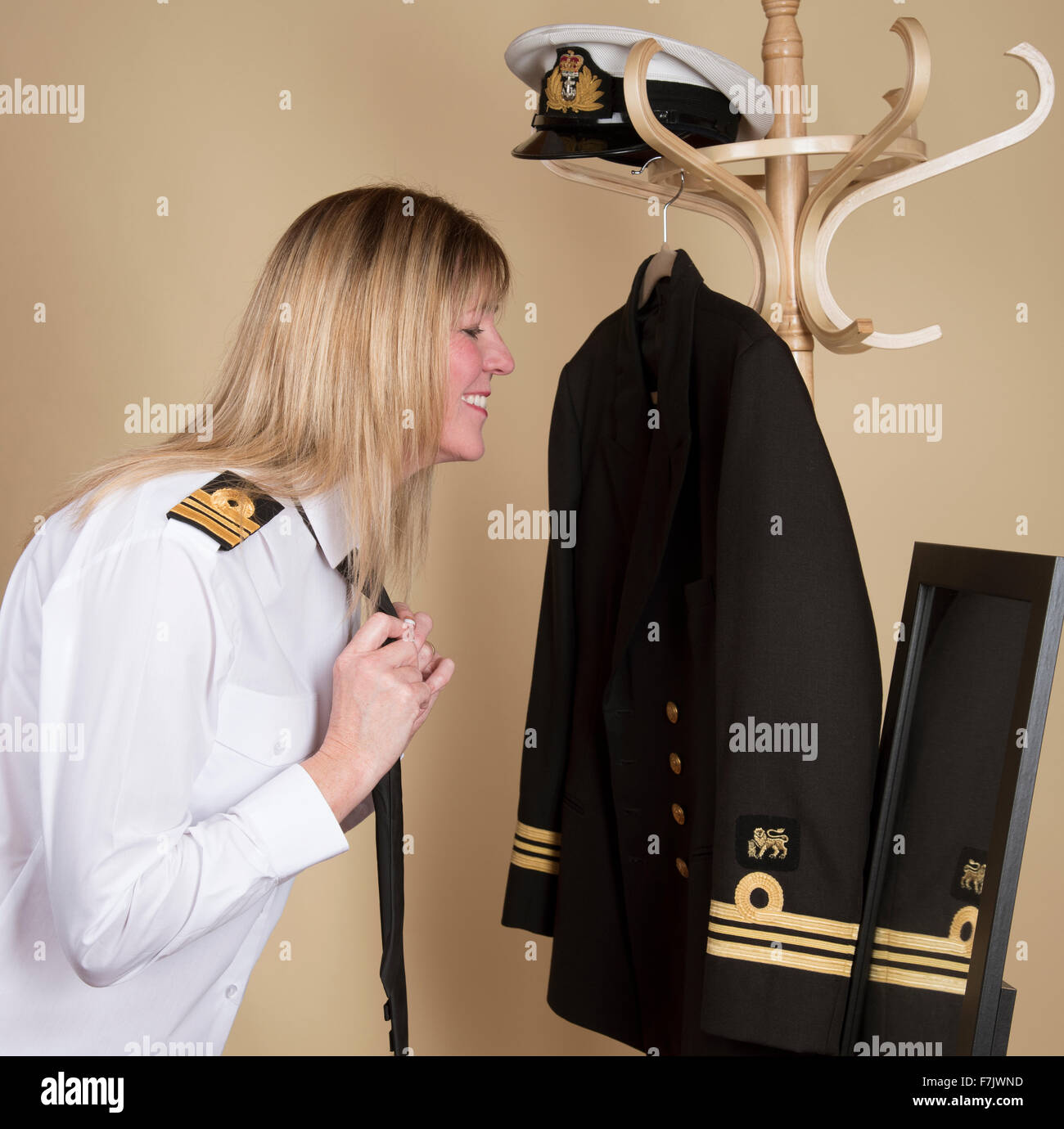 Female naval Lt Commander getting ready for duty Tying her black ...