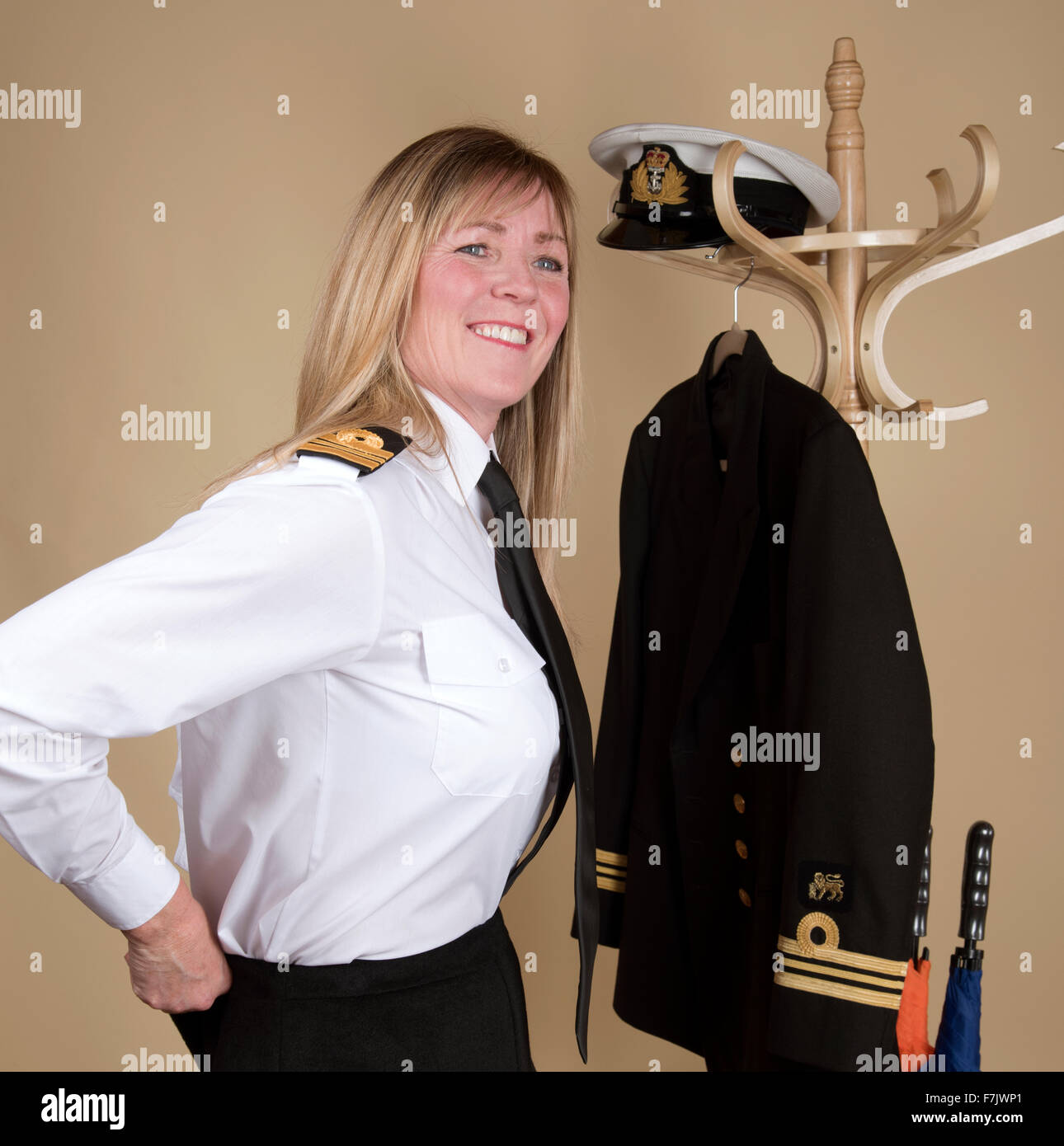 Female naval Lt Commander getting ready for duty tucking shirt into ...