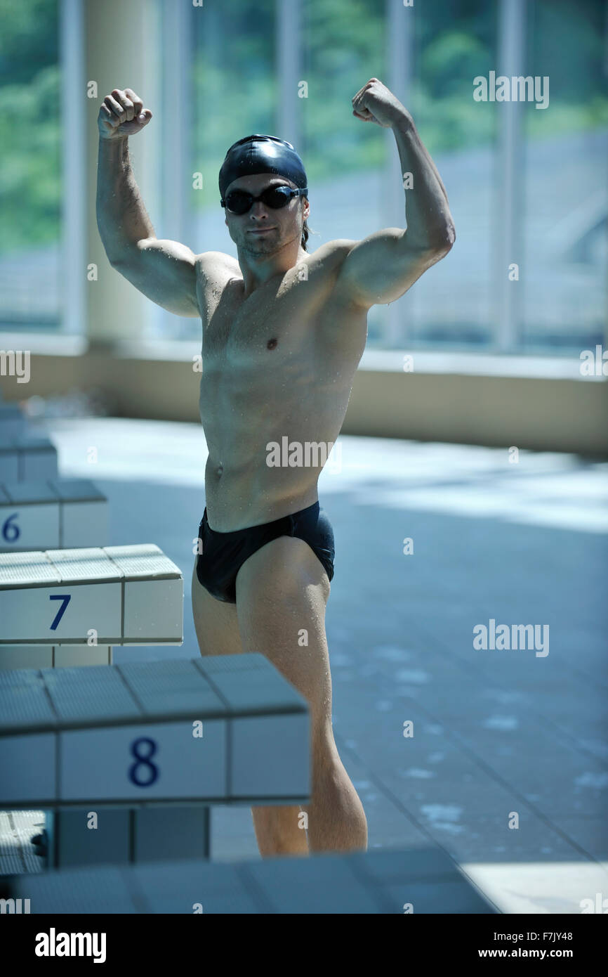 young swimmer on swim start at swimming pool ready for jump race and ...