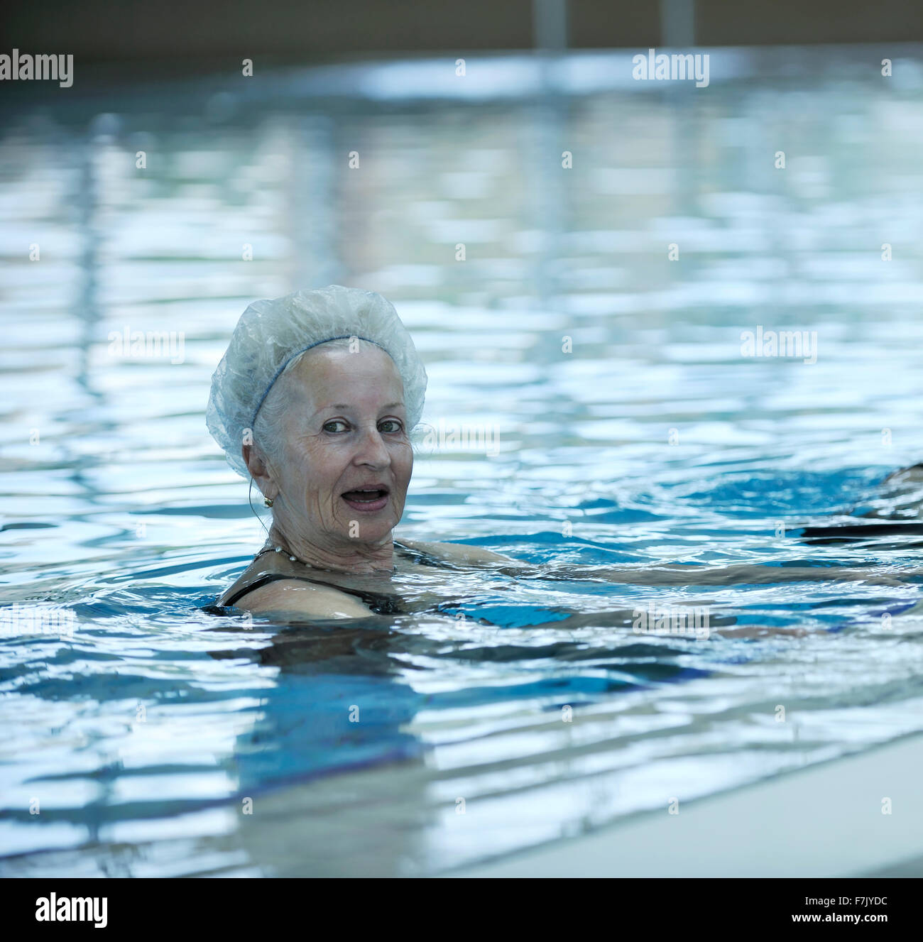 young swimmer on swim start at swimming pool ready for jump race and ...