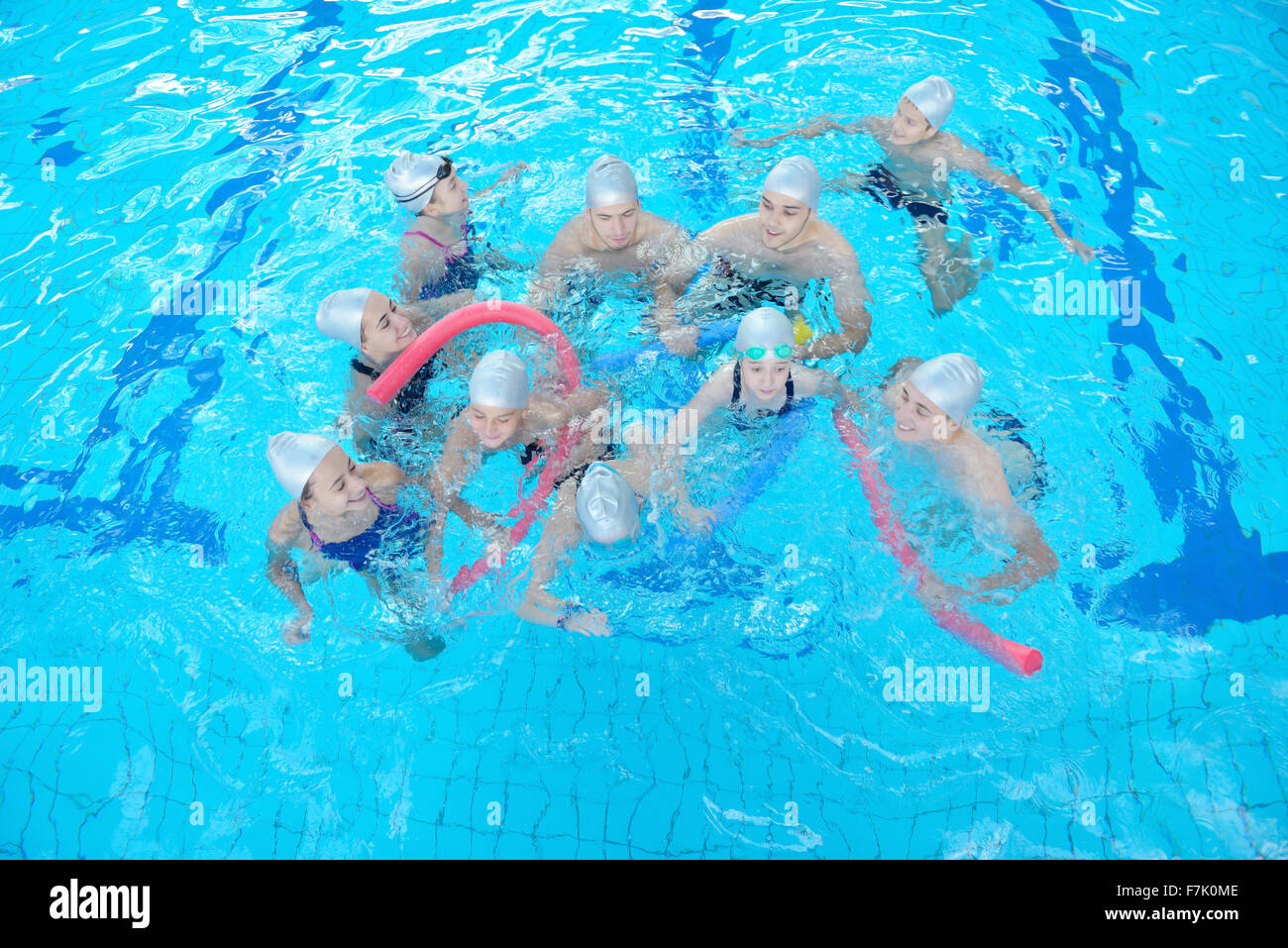 group of happy kids children at swimming pool class learning to swim ...