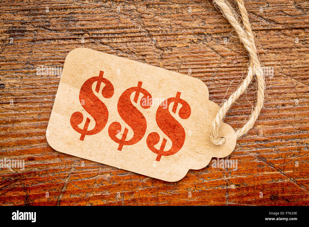 triple dollar sign - red stencil text on a paper price tag against ...