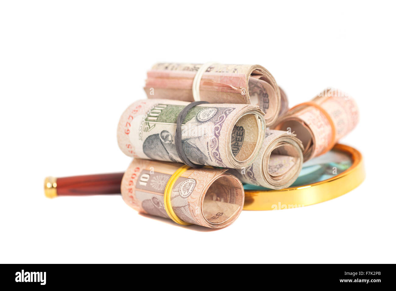 Rolls of Indian Currency Rupee Notes with magnifying glass isolated on ...