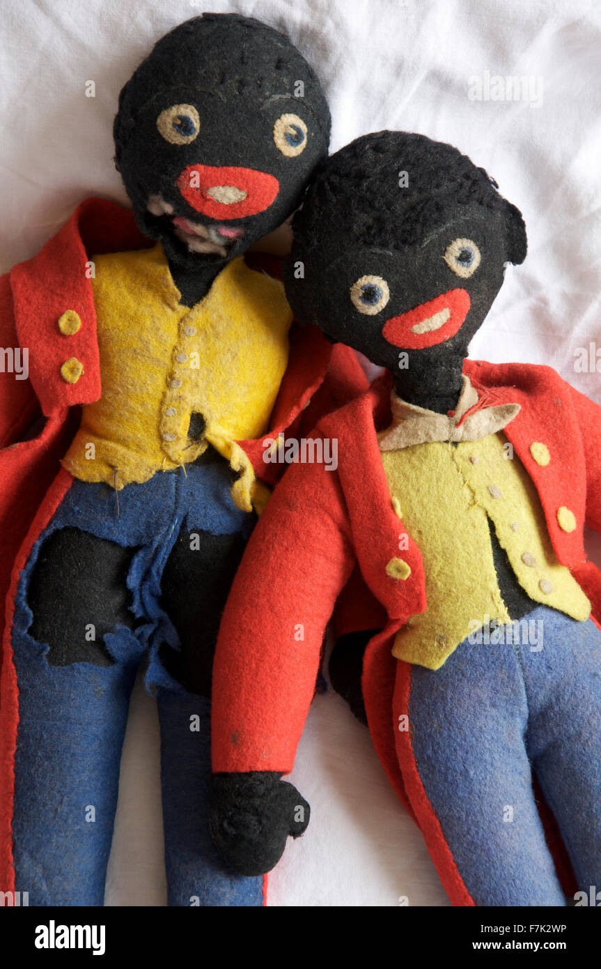 Two old well worn and much loved golliwog dolls lying together on a ...