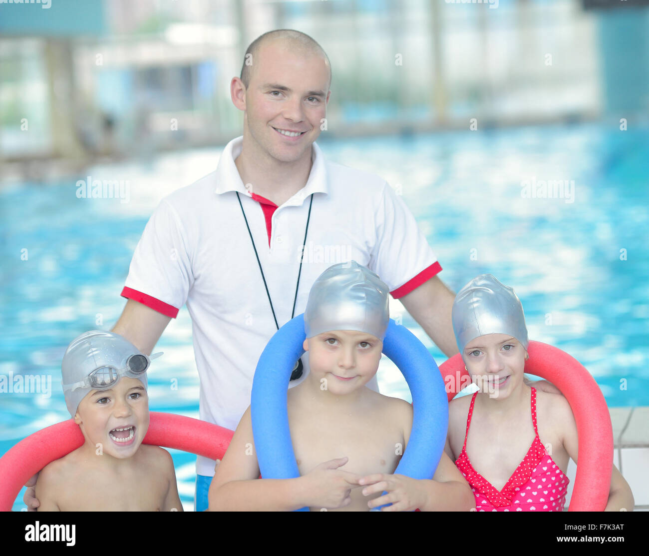 group of happy kids children at swimming pool class learning to swim ...