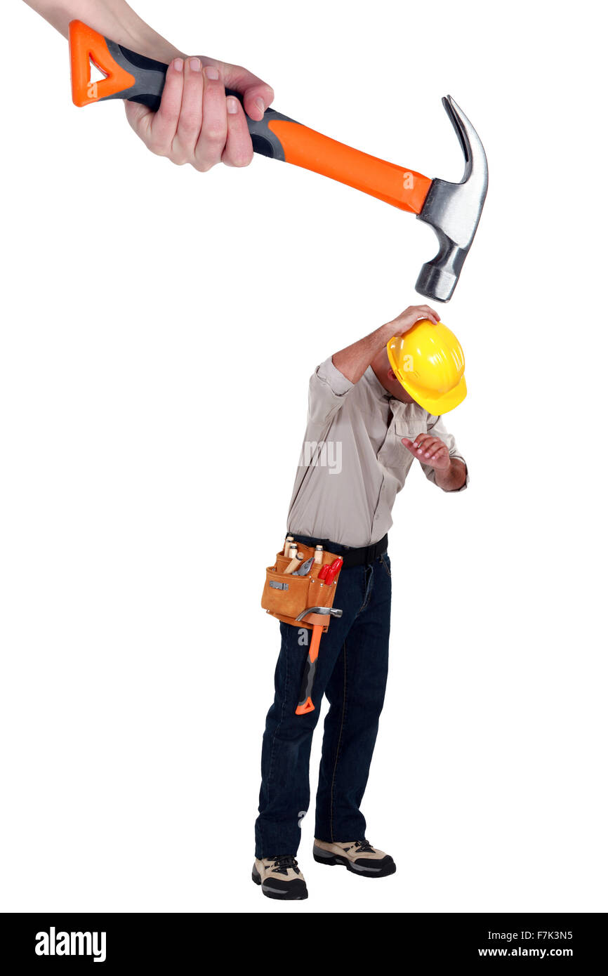 Builder being attacked by giant hammer Stock Photo - Alamy