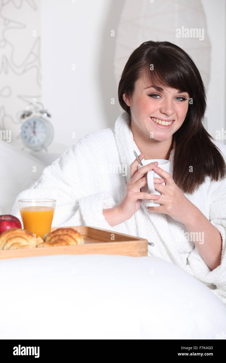 Young woman having breakfast in bed Stock Photo - Alamy