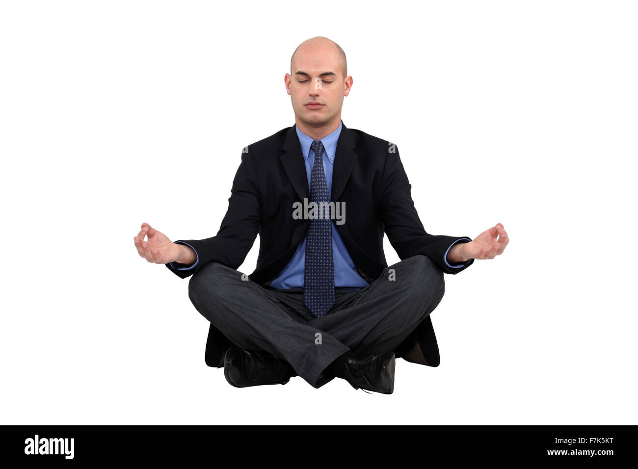 Businessman sat in yoga position Stock Photo - Alamy