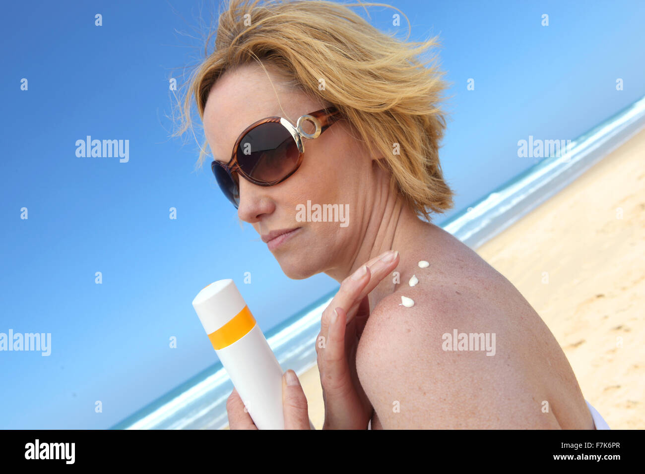 Woman putting on sun cream Stock Photo - Alamy