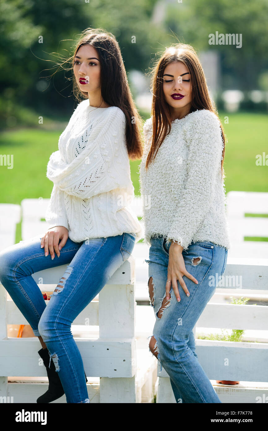 Two girls lean bench Stock Photo - Alamy