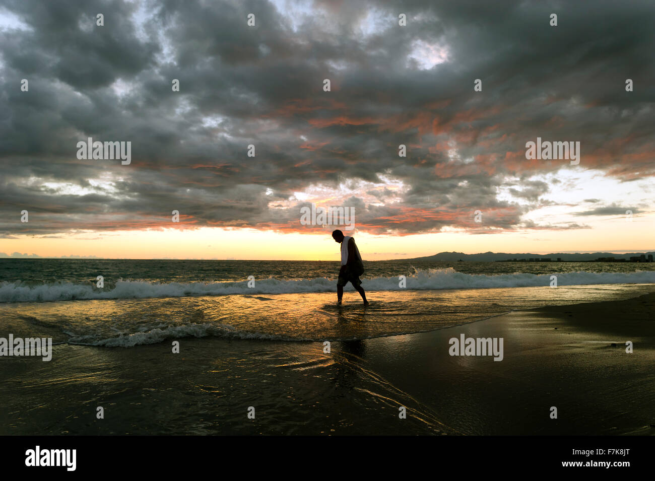 Solitude man is a man walking on the beach appearing alone in water ...