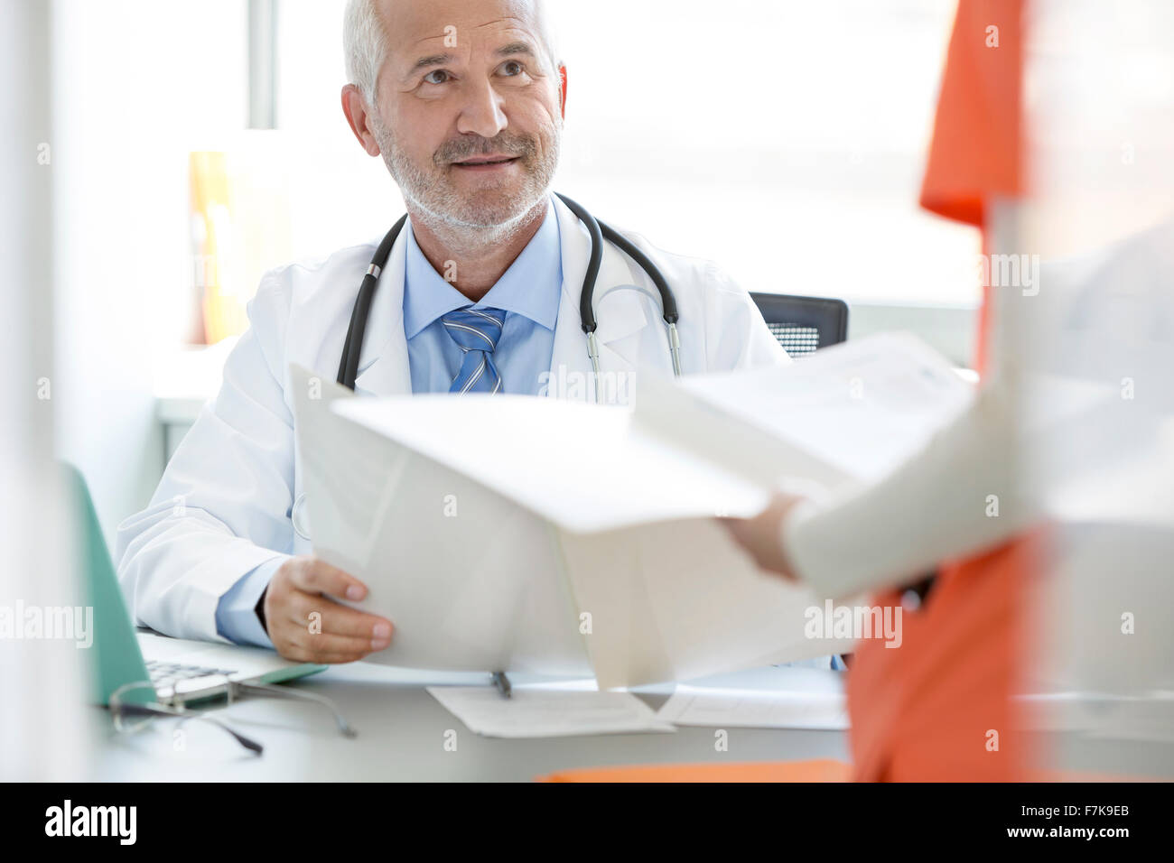 Doctor and nurse reviewing medical record in doctor’s office Stock ...