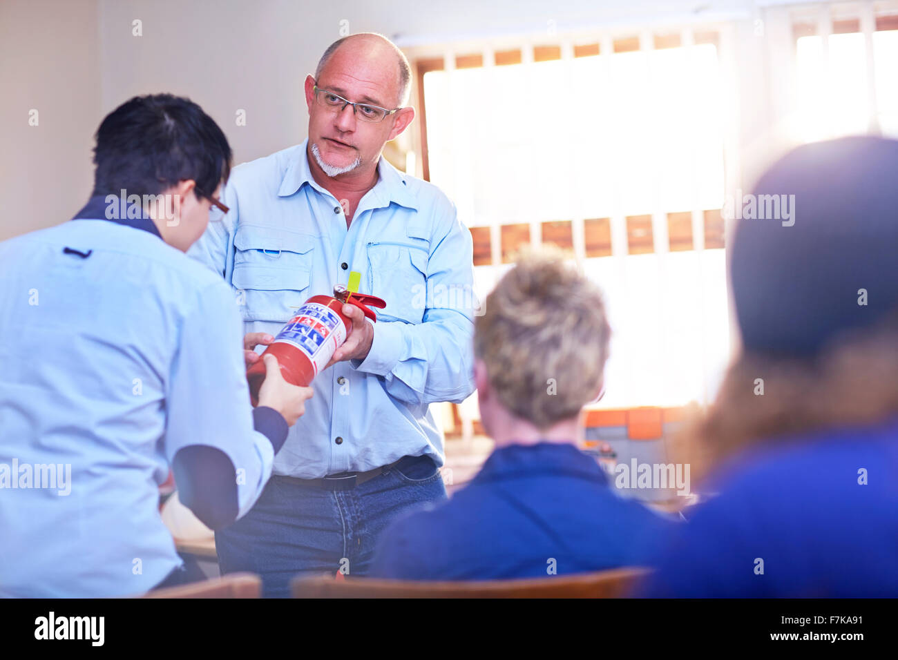 Instructor explaining how to use fire extinguisher in training class ...