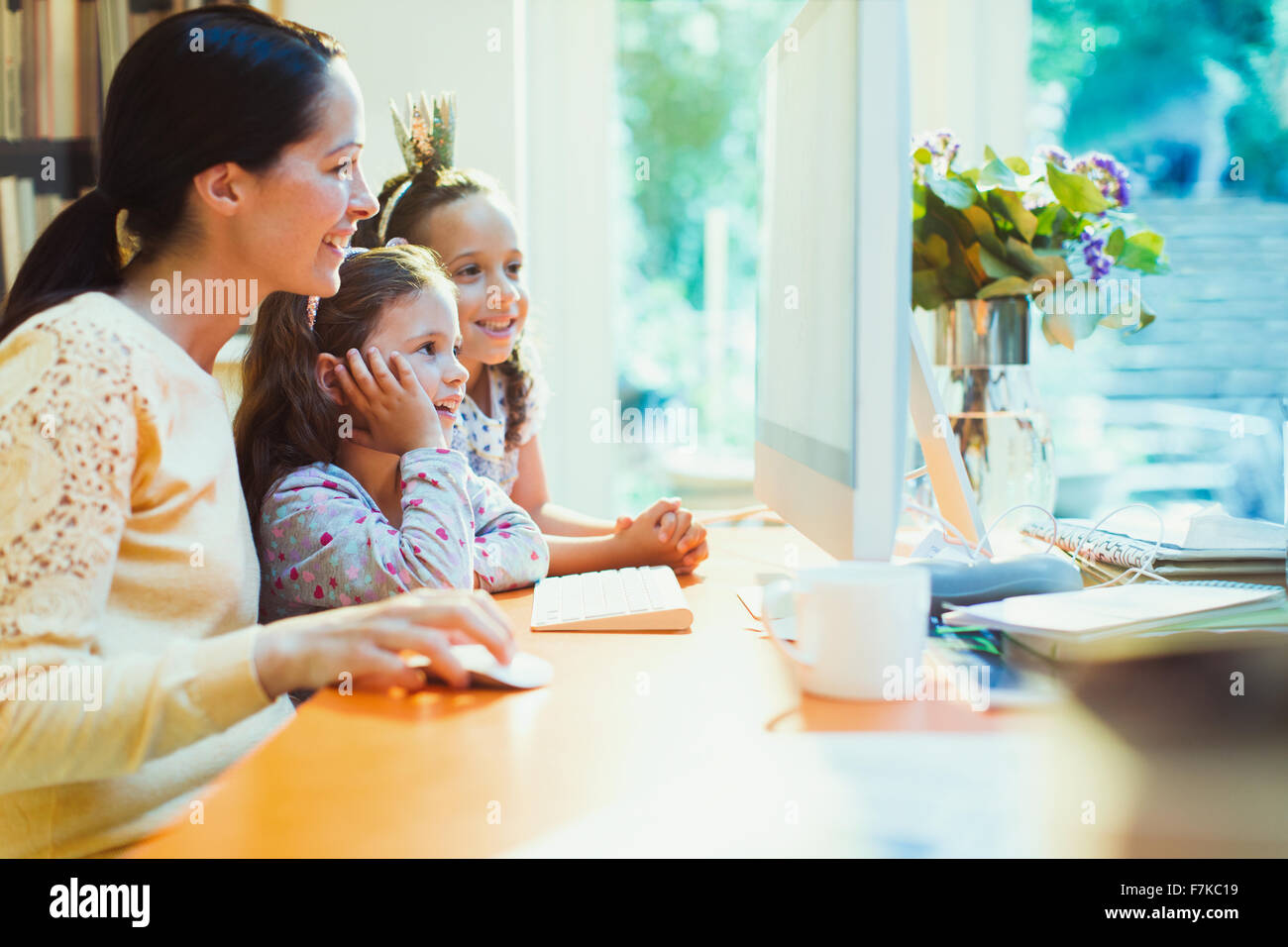 Mother and daughters using computer Stock Photo - Alamy
