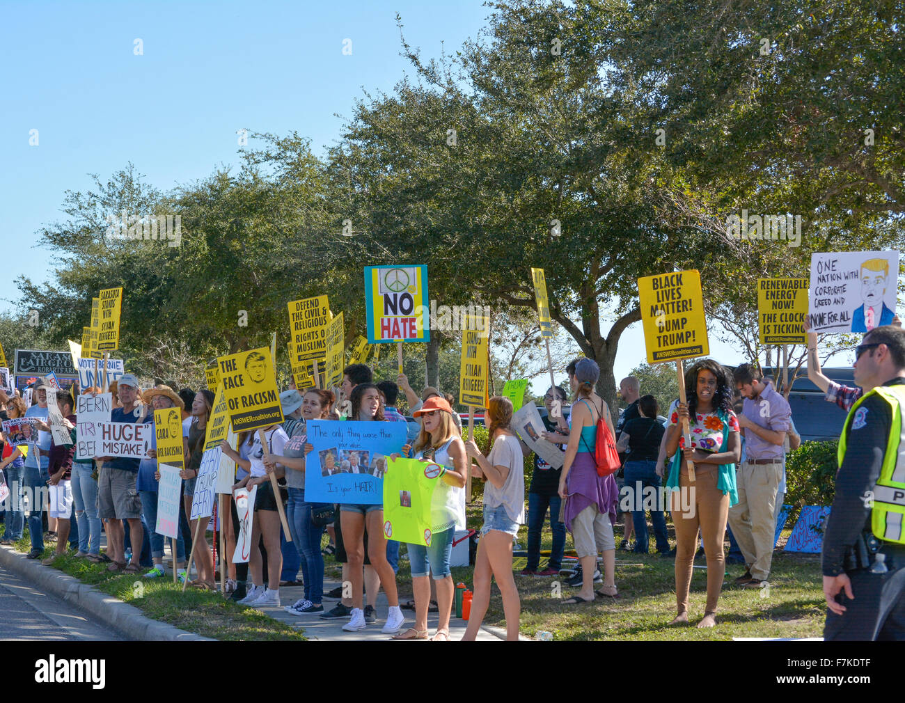 Protesters holding signs denouncing Donald Trump at a political rally ...