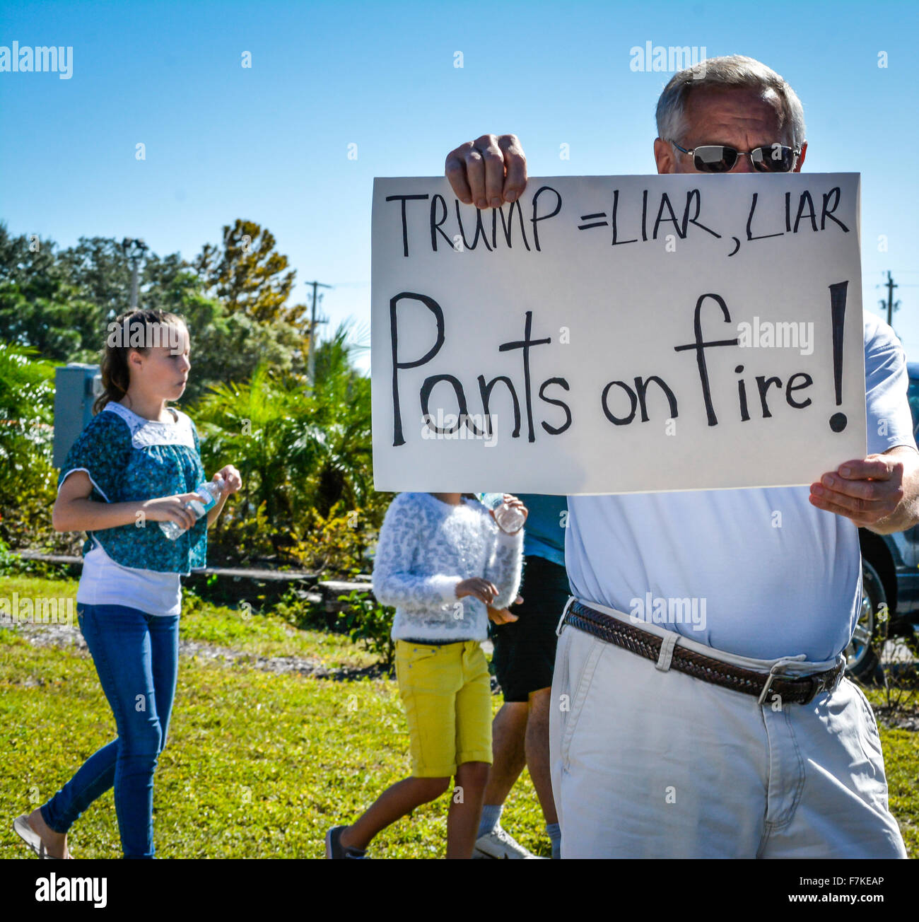 Protesters holding signs denouncing Donald Trump at a political rally ...